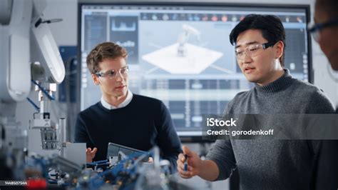 남학생이 동급생과 흑인 교사와 함께 프로젝트를 진행하는 동안 태블릿을 들고 몸짓을 하고 있다 수업 중 현대 기술을 분석하는