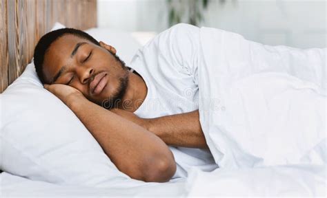 African American Guy Sleeping Resting In His Bed At Home Stock Image