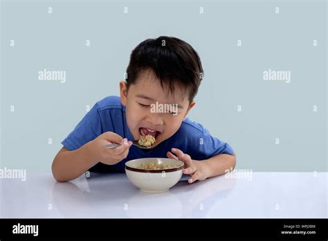 The Asian Boy Is Eating Delicious Rice And Has A Very Happy Face Stock