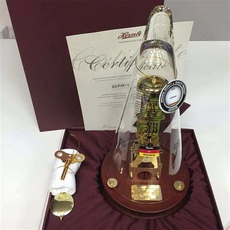 An Award Is Displayed On Top Of A Table With A Clock And Wine Bottle In It