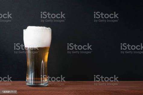 술집에 있는 나무 테이블에 유리 맥주 잔에 거품 차가운 맥주 텍스트 메뉴 모형을 위한 배경으로 어두운 검은 벽 0명에 대한 스톡 사진 및 기타 이미지 Istock