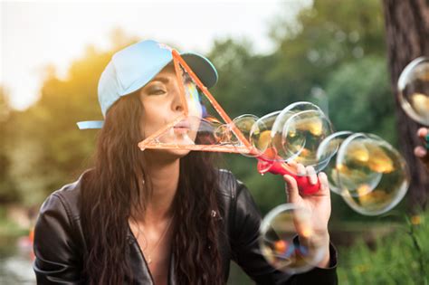 화창한 날에 함께 여름 공공 공원에서 비누 거품이있는 녹색 잔디밭에서 즐거운 시간을 보내는 아들과 함께하는 어머니 좋은 봄철에 휴식과 재미를 가진 가족 개념 모성 어린 시절