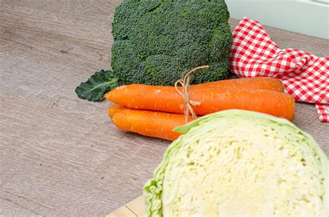 나무 도마에 신선한 녹색 브로콜리 당근 마늘 양파와 양배추 매크로 사진 녹색 신선한 야채 브로콜리 식이 요법과 건강한 식사를위한 녹색 야채 유기농 식품 준비 농업에 대한