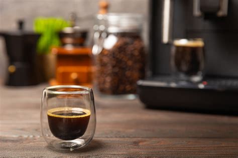 식탁에 컵이 있는 현대적인 커피 머신 커피 하우스 주방에 컵이 있는 현대적인 에스프레소 커피 머신 향기로운 뜨거운 음료의 준비