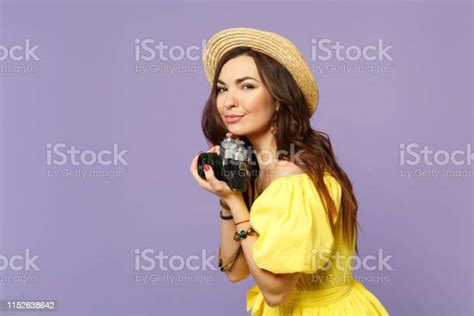 노란 드레스 여름 모자 파스텔 바이올렛 벽 배경에 고립 된 복고풍 빈티지 사진 카메라에 사진을 찍는 멋진 젊은 여자 사람들은