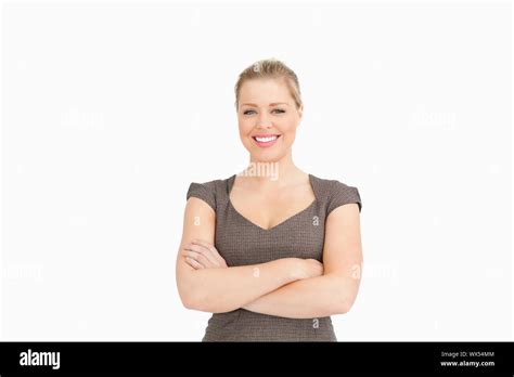 Woman Smiling With Her Arms Crossed Against White Background Stock