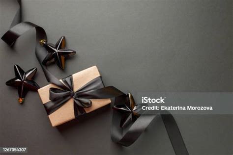 어두운 검은 색 배경에 새틴 검은 리본아름다운 최소한의 크리스마스 황금 검은 장식과 종이 공예 선물 상자 플랫 레이 디자인