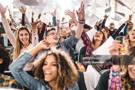 Cheerful College Students Having Fun While Throwing Papers In The