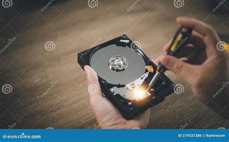 Close Up Of Hard Disk Internal Mechanism Hardware HDD In Hand With A Screwdriver Stock Photo