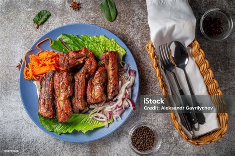 레스토랑 메뉴에서 요리를 제공합니다 회색 돌 탁자 맛있는 케밥에 접시에 강판 당근과 허브를 곁들인 구운 쇠고기와 돼지고기 고기 0명에 대한 스톡 사진 및 기타 이미지