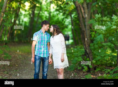 Portrait Of A Young Romantic Couple Kissing Each Other On Nature Stock