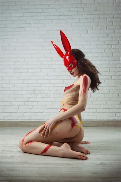 A Naked Woman In A Red Rabbit Mask Poses Against A Brick White Wall Stock Image Image Of