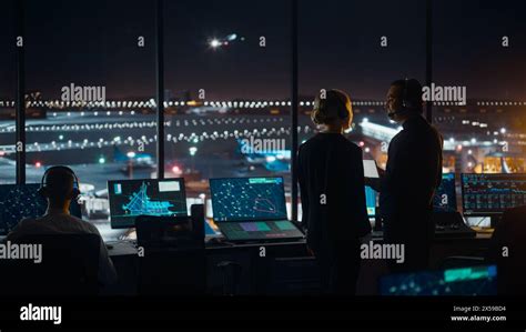 Female And Male Air Traffic Controllers With Headsets Talk In Airport