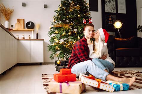 크리스마스 선물교환 크리스마스 트리 근처 아늑한 거실에서 선물 상자를 여는 젊은 부부 2명에 대한 스톡 사진 및 기타 이미지 2명 가족 겨울 Istock