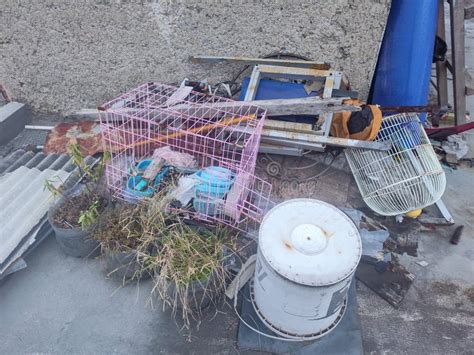 A Pile Of Discarded Objects On A Rooftop Including Rusty Metal Scraps