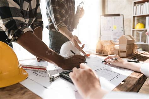 Architect Team Working With Blueprints For Architectural Construction