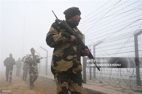 Border Security Force Personnel Patrol Along The Border Fence During