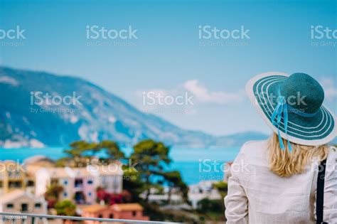관광 여자 블루 Sunhat과 흰색 옷을 입고 맑은 날에 다채로운 조용한 마 아소스의 보기에 감탄 세련 된 여성 방문 Kefalonia 그리스 여행 휴가 여름 시간을 즐기고