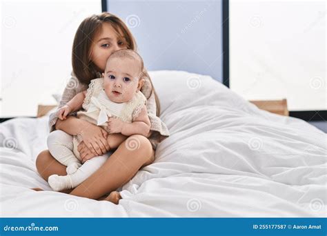 Hermano Y Hermana Se Abrazan Entre Ellos Sentados En La Cama En El Dormitorio Imagen De Archivo