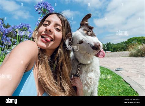 Selfie Portrait Of Young Colombian Latina Woman With Her Border Collie Dog In The Park