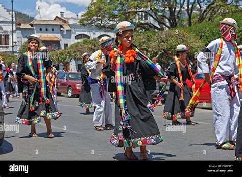Indigenous People With Traditional Costumes Dancing In The Street Of