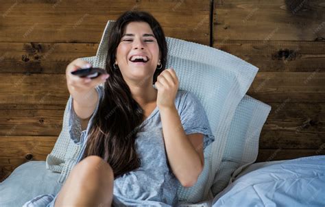 Hermosa Mujer Viendo Televisión Y Acostado En La Cama Foto Premium