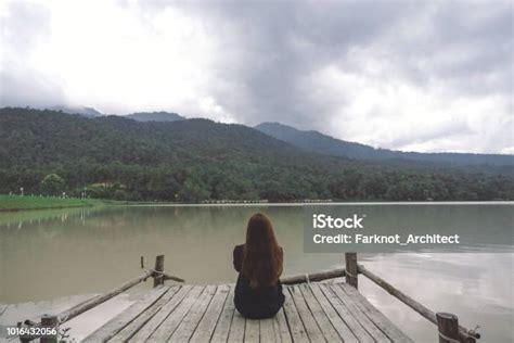 하늘과 산을 배경으로 강 오래 된 목재 부두에 혼자 앉아있는 여자의 근접 촬영 이미지 강에 대한 스톡 사진 및 기타 이미지 강 고독 부정적인 감정 표현 나무 Istock