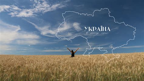 A Person Standing In A Wheat Field With Their Arms Up And The Map Of Ukraine Behind Them