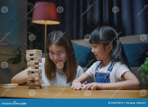 Aziatische Jonge Moeder Speelt Spel In Houten Blok Met Haar Dochter Thuis In De Woonkamer Stock