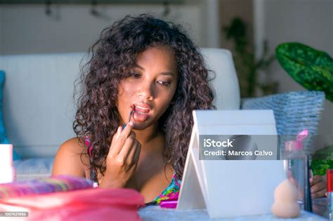 영 행복의 라이프 스타일 초상화와 아름 다운 라틴 아메리카 여자 여성 아름다움 피부 케어 개념에서 거울을 보고 얼굴 메이크업을 적용 하는 그녀의 입술에 립글로스 연필을 사용