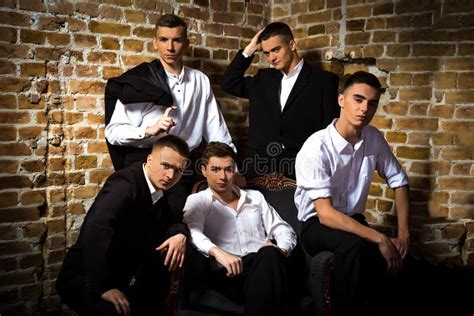 Un Gruppo Di Giovani Bei Ragazzi Sexy Che Posano Contro Un Muro Di Mattoni Fotografia Stock