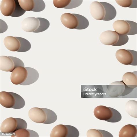 베이지색 그라데이션 색상의 달걀 껍질이 있는 부활절 달걀 프레임 햇빛에 딱딱한 그림자 복사 공간이 있는 흰색 배경 닭고기 달걀 레이아웃 평면도 최소 평면 누워 휴일 음식