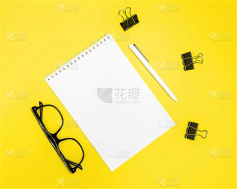 黄色背景上的记事本、钢笔、眼镜和活页夹。平铺，俯视图，拷贝空间。