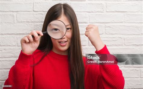 돋보기 화가 미친과 제기 손으로 소리 분노와 좌절 외치고 분노 개념을 찾고 하는 벽돌 벽을 통해 젊은 중국 여자 감정에 대한