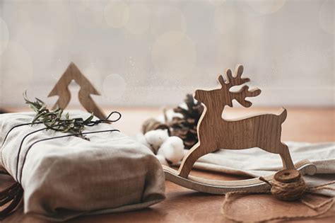 세련 된 크리스마스 소박한 선물 소나무 콘 순 록 꼬기 면 나무 테이블에 녹색 분 지와 린 넨 원단에 싸여 있다 간단한 에코 플라스틱 무료 제공합니다 제로 폐기물 휴일입니다