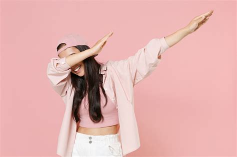 파스텔 핑크 월 배경 스튜디오 초상화에 고립 포즈 캐주얼 옷 모자에 젊은 아시아 여자 소녀 사람들은 진지한 감정 라이프 스타일 개념 복사 공간을 모의합니다 Dab 댄스