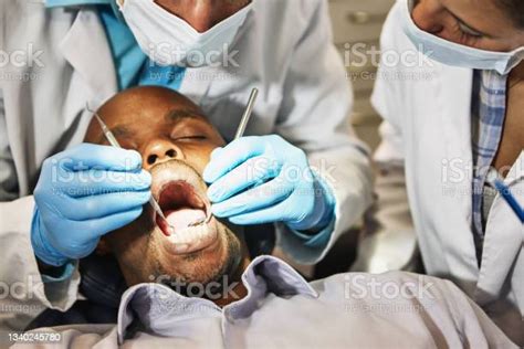 치과 의사와 치과 간호사는 수술에서 입을 벌리고 기대어 환자를 검사합니다 18 19세에 대한 스톡 사진 및 기타 이미지 18 19세 20 29세 3 명 Istock