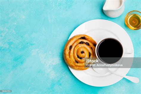 파란 테이블 배경에 검은 커피 한 잔과 건포도신선한 덴마크 페이스트리 맨 위 보기 공간을 복사합니다 커피 마실 것에 대한 스톡