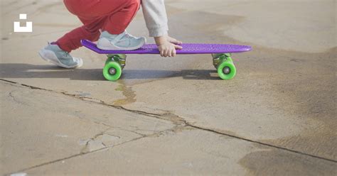 낮 동안 녹색 킥 스쿠터를 타고 흰색과 빨간색 까마귀를 입은 소녀 사진 Unsplash의 무료 사람의 이미지