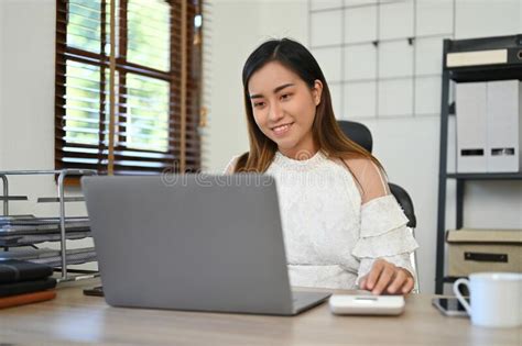 Asian Businesswoman Working At Her Desk Using Laptop Computer To