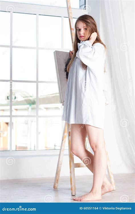 Девушка в рубашке около большого окна утро с его мольбертом Стоковое