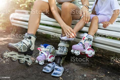 어머니와 딸이 함께 공원에서 스케이트를 탄 후 벤치에서 인라인 롤러를 벗고 있다 가족 레저 스포츠 활동 주말 네거티브 공간 복사 롤러 스케이트에 대한 스톡 사진 및 기타