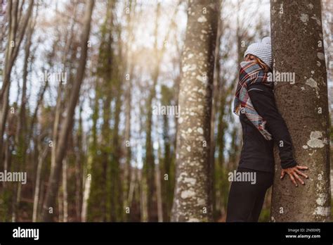 A Woman Is Leaning Against The Trunk Of A Tree In A Beautiful Forest She Embraces The Tree And