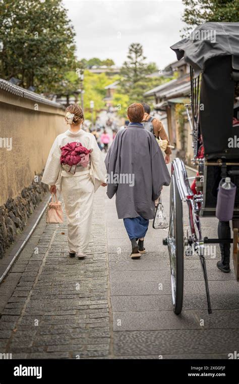 A Couple In Japanese Kimono Walking Down A Traditional Street Kyoto