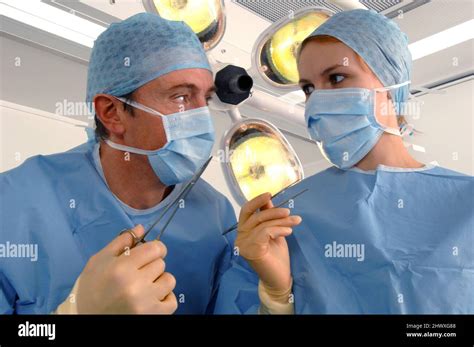 Male Doctor Holding Scalpel And Female Doctor Holding Forceps In A Hospital Operating Theatre