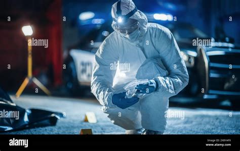 Portrait Of Two Forensics Experts Doing Fieldwork At Night At A Crime Scene One Technician