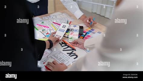 Dynamic Ux Ui Team Reviewing Mobile App Wireframes And Sketches During A Collaborative Design