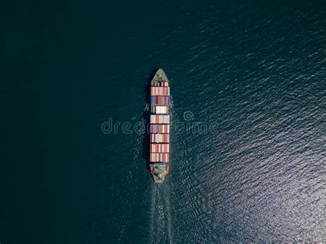 A Container Ship Moves Steadily Through The Ocean Carrying Stacked Containers Stock Photo