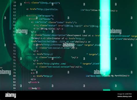Close Up Of Computer Screen With Codes And Symbols With Computer Hacker In Black Clothing In The