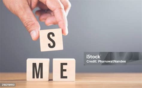 회색 배경에 Sme라는 글자가 적힌 나무 블록을 테이블 위에 정리하는 손 중소기업의 개념 비즈니스 환경에서의 중요성을 강조합니다 개념에 대한 스톡 사진 및 기타 이미지